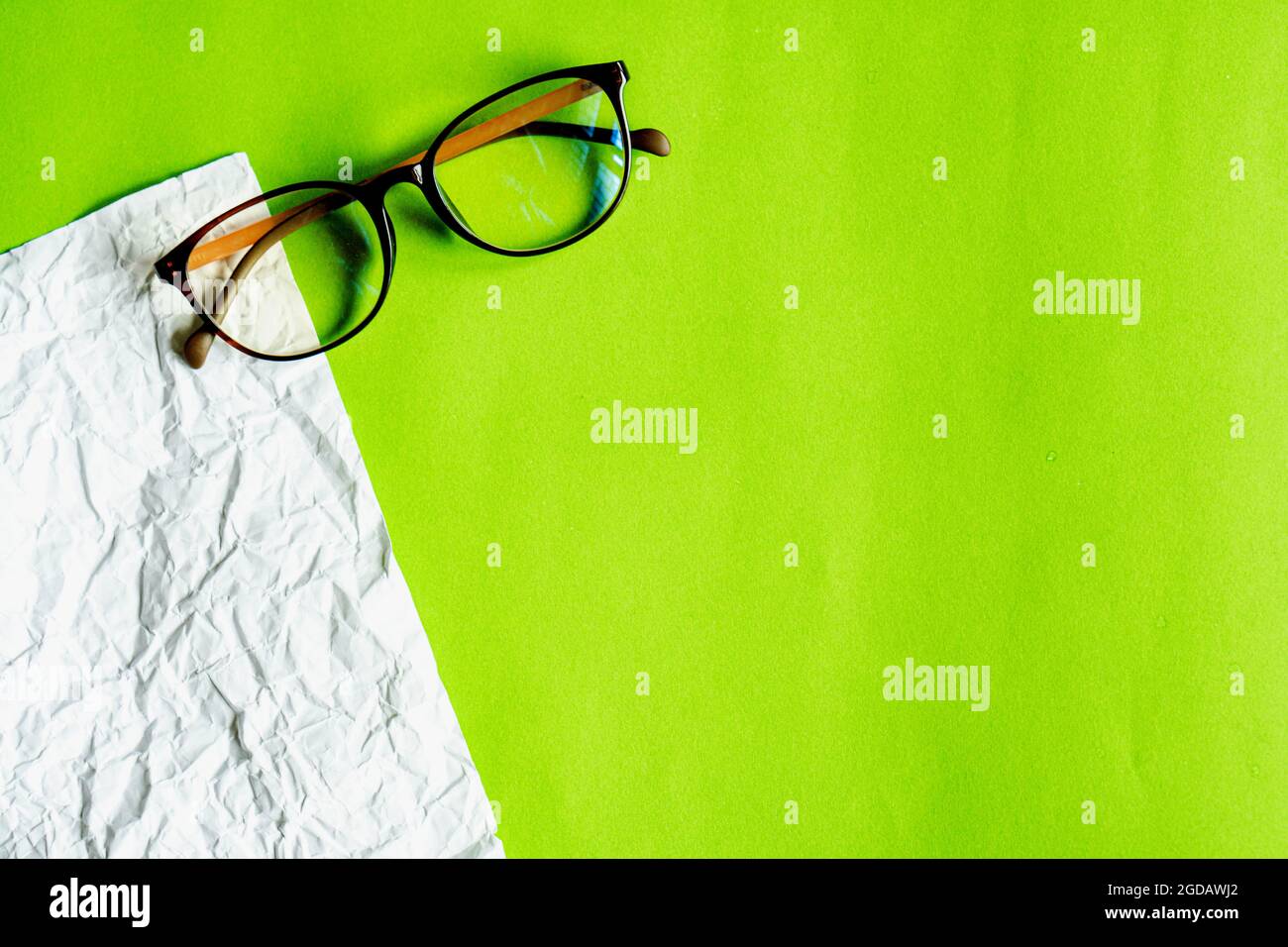White crumpled paper and green paper. eyeglass concept Stock Photo - Alamy