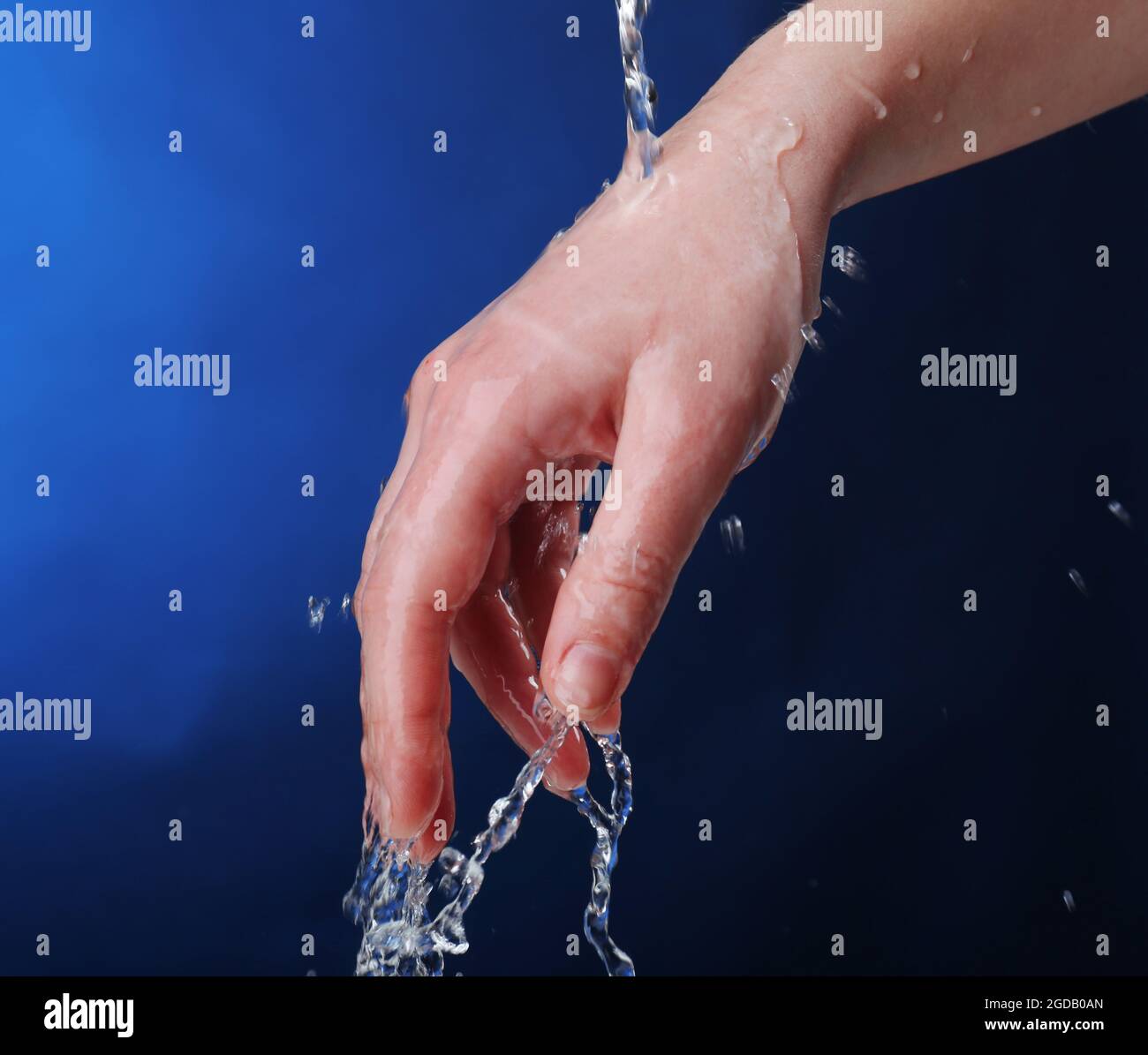 Human hand with water splashing on them on dark blue background Stock ...