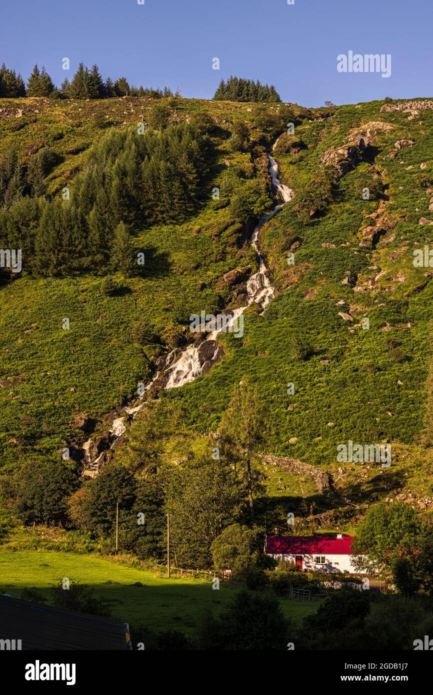 Carawaystick waterfall and red roofed whitewashed cottage in Glenmalure ...