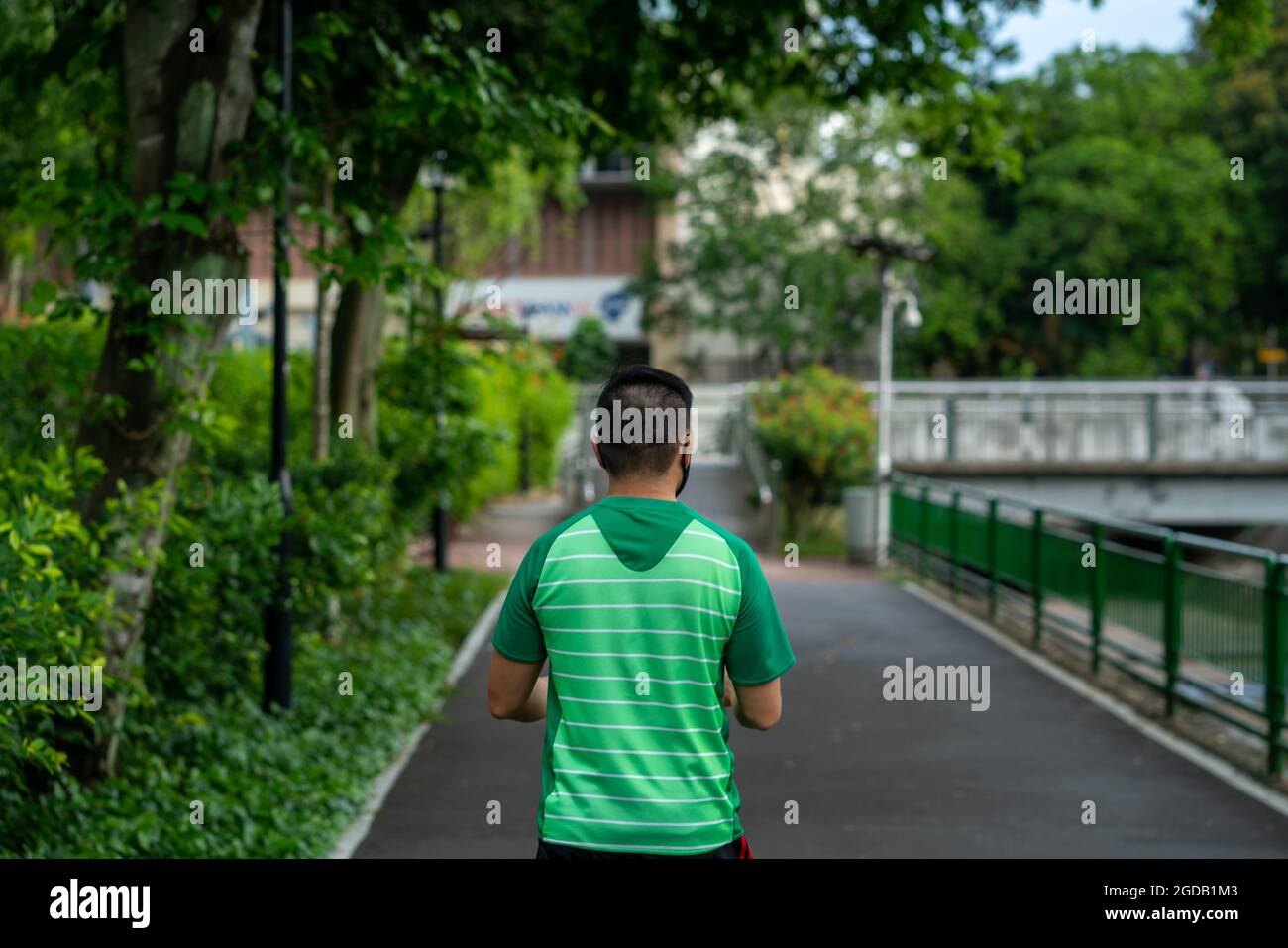 Medium shot of Chinese man walking on a park, Singapore Stock Photo - Alamy