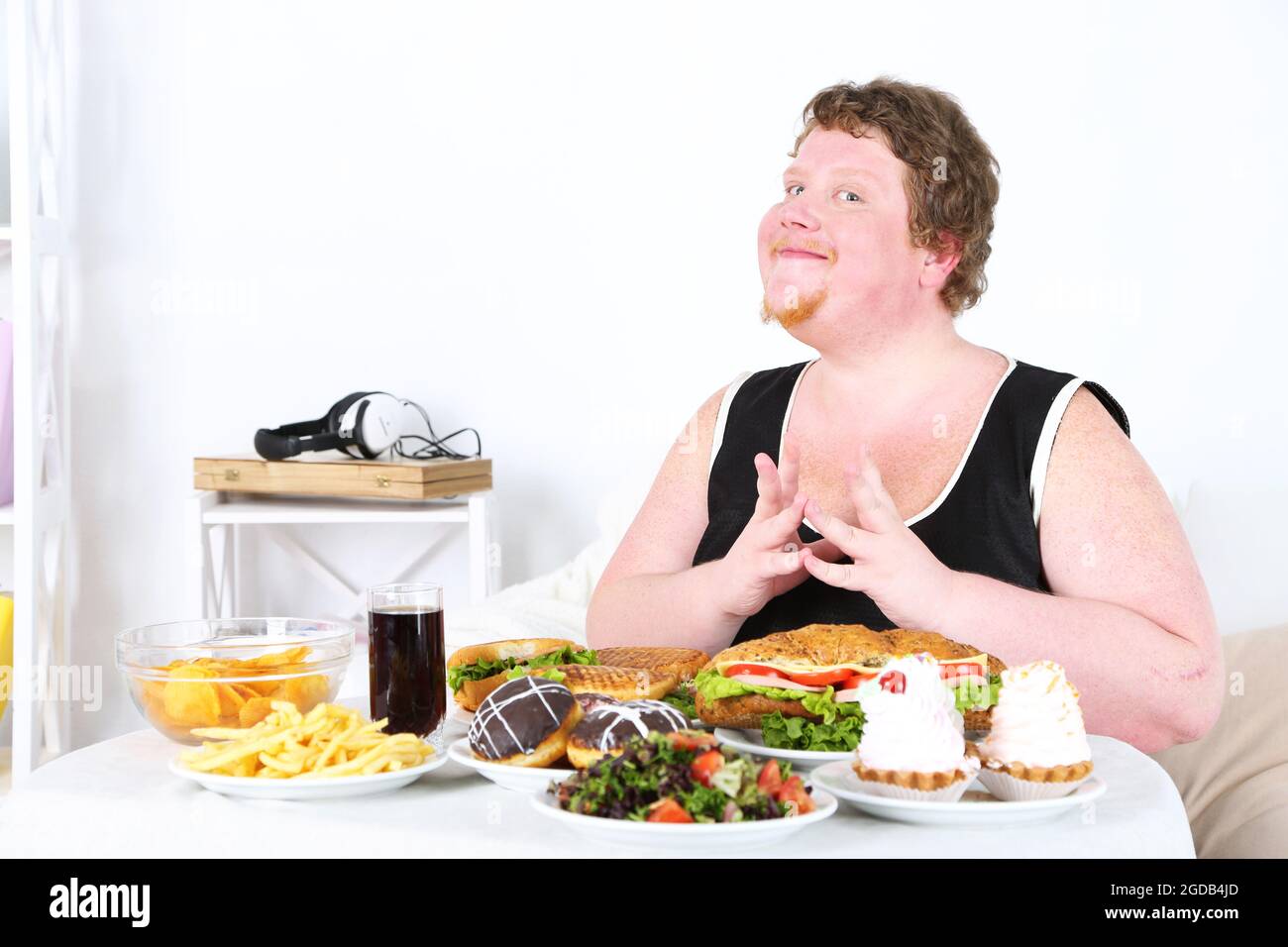 Fat man has a big lunch, on home interior background Stock Photo - Alamy