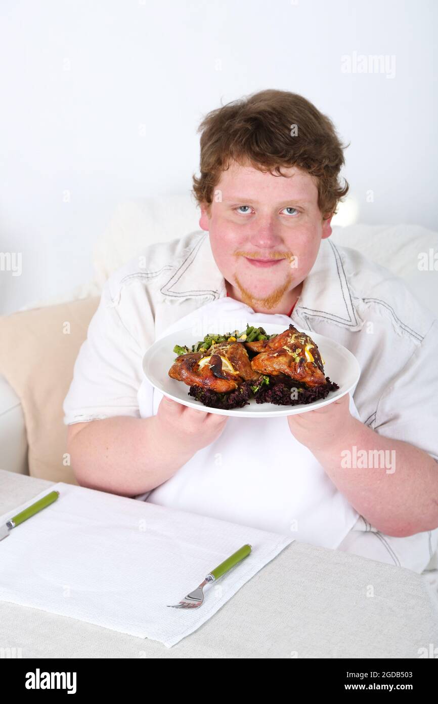 Tasty lunch for fat man, on home interior background Stock Photo - Alamy