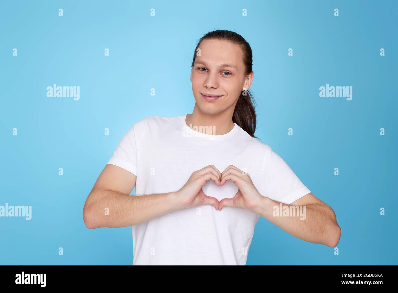 Handsome young man making heart sign with his hands fingers hi-res ...