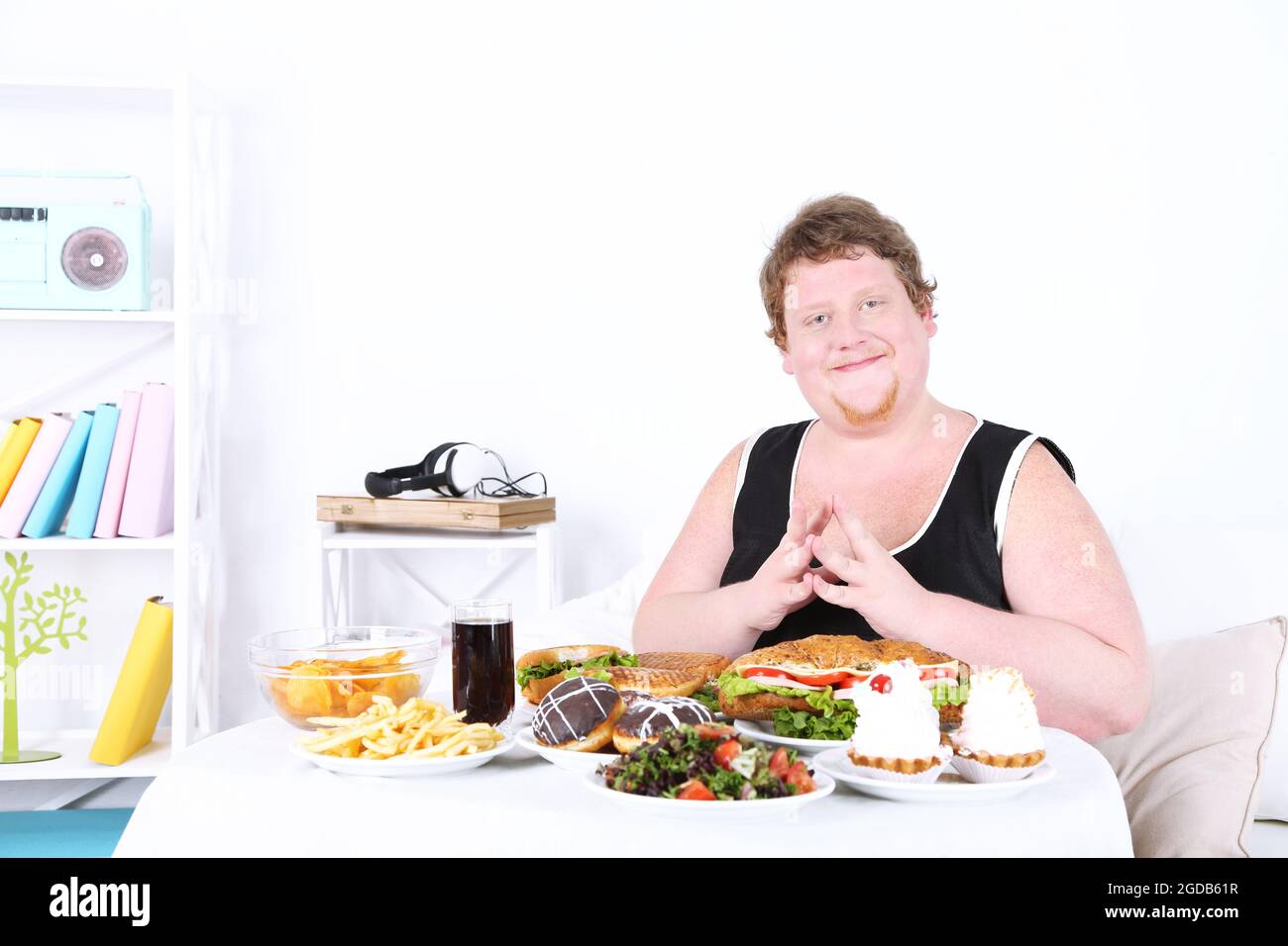 Fat man has a big lunch, on home interior background Stock Photo - Alamy