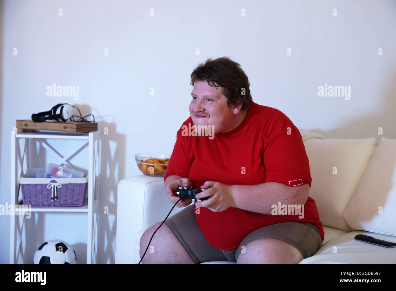 Fat man playing video games on home interior background Stock Photo - Alamy
