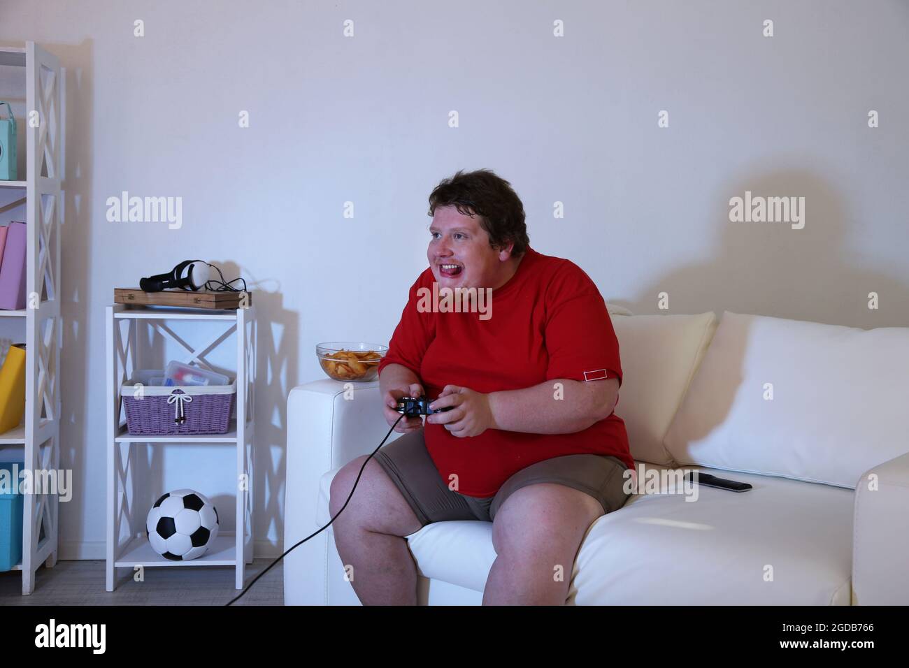 Fat man playing video games on home interior background Stock Photo - Alamy