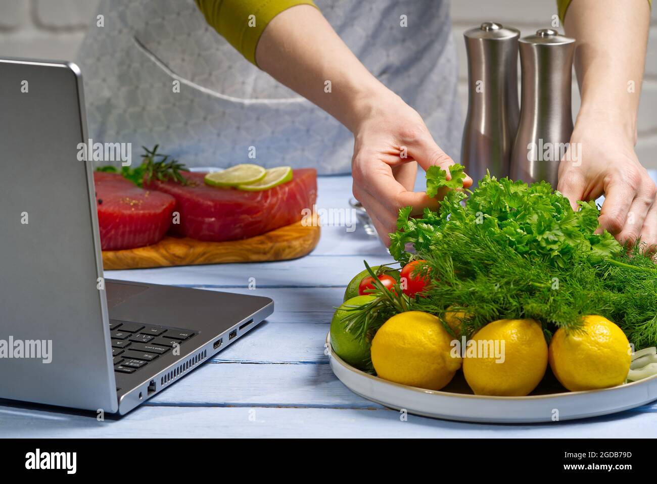 cooking and computer laptop concept. cooking woman in kitchen with pc ...