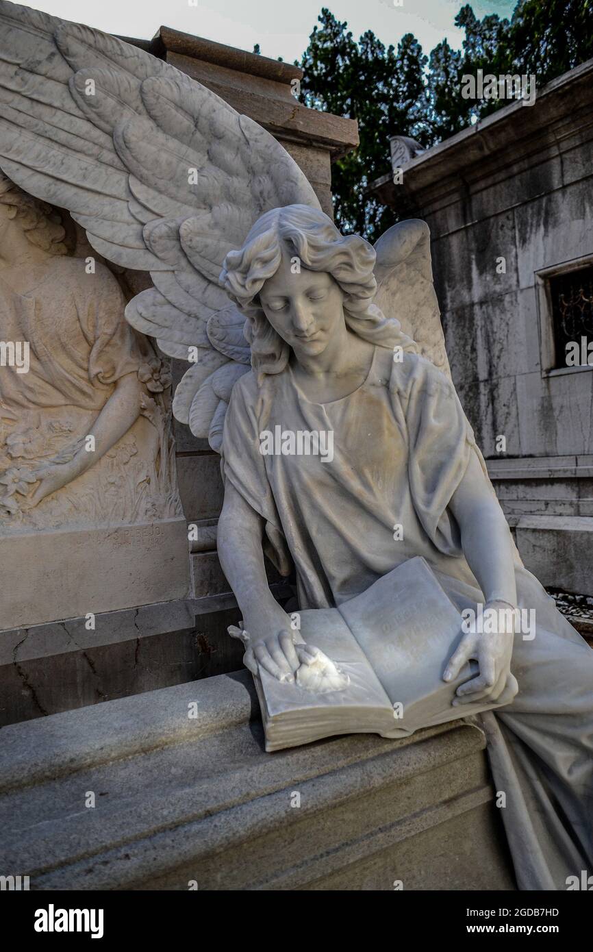 statue of angel reading next to a pantheon Stock Photo - Alamy