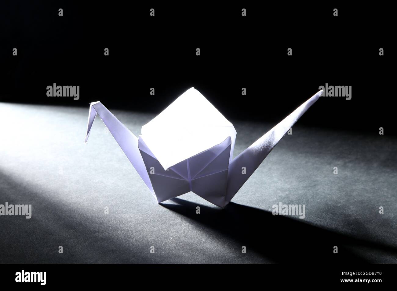 Origami crane on dark background with light Stock Photo - Alamy