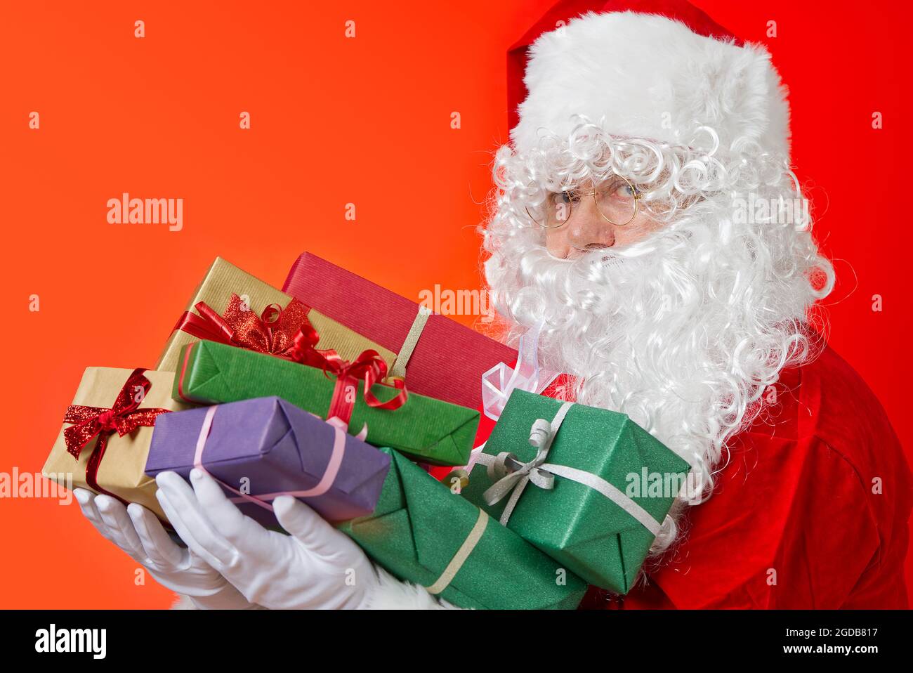 Happy Santa Claus with gift boxes in hands on red background with copy ...