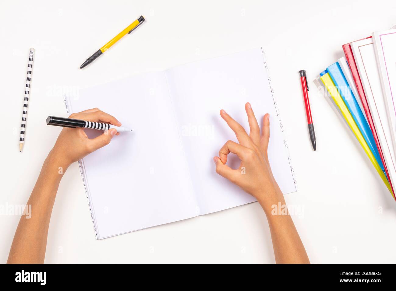 Kid holding pencil in left hand for writing in notebook, doing homework ...