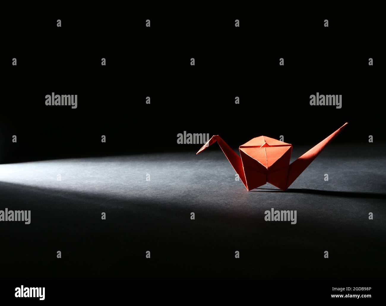 Origami crane on dark background with light Stock Photo - Alamy