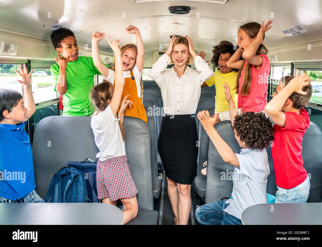 Group of young students attending primary school on a yellow school bus ...