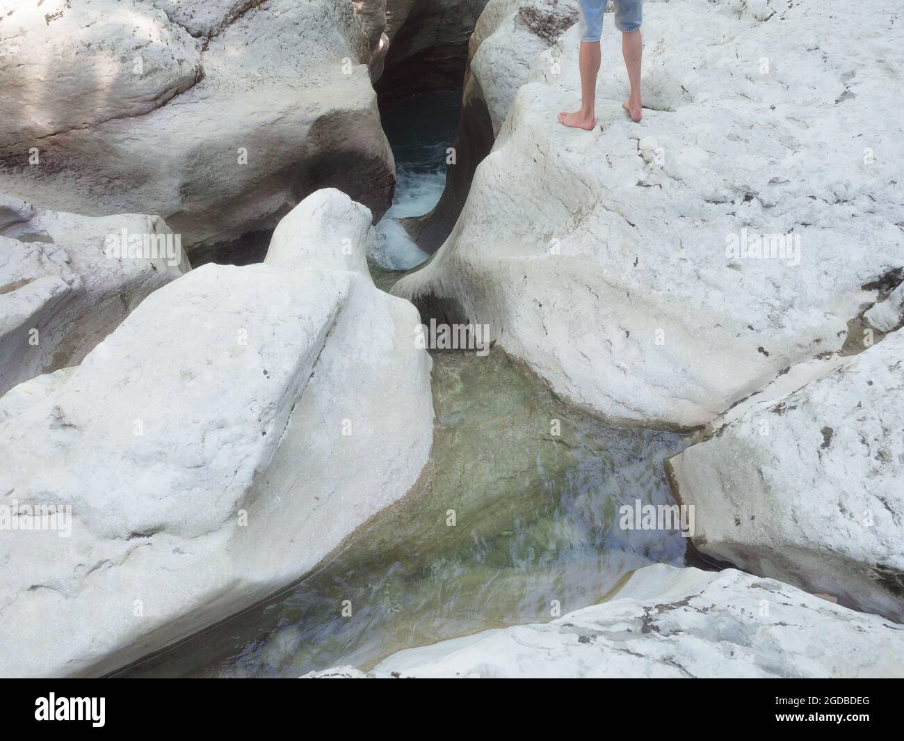 Smooth white rocks with stream of water flowing in the cracks. River in ...