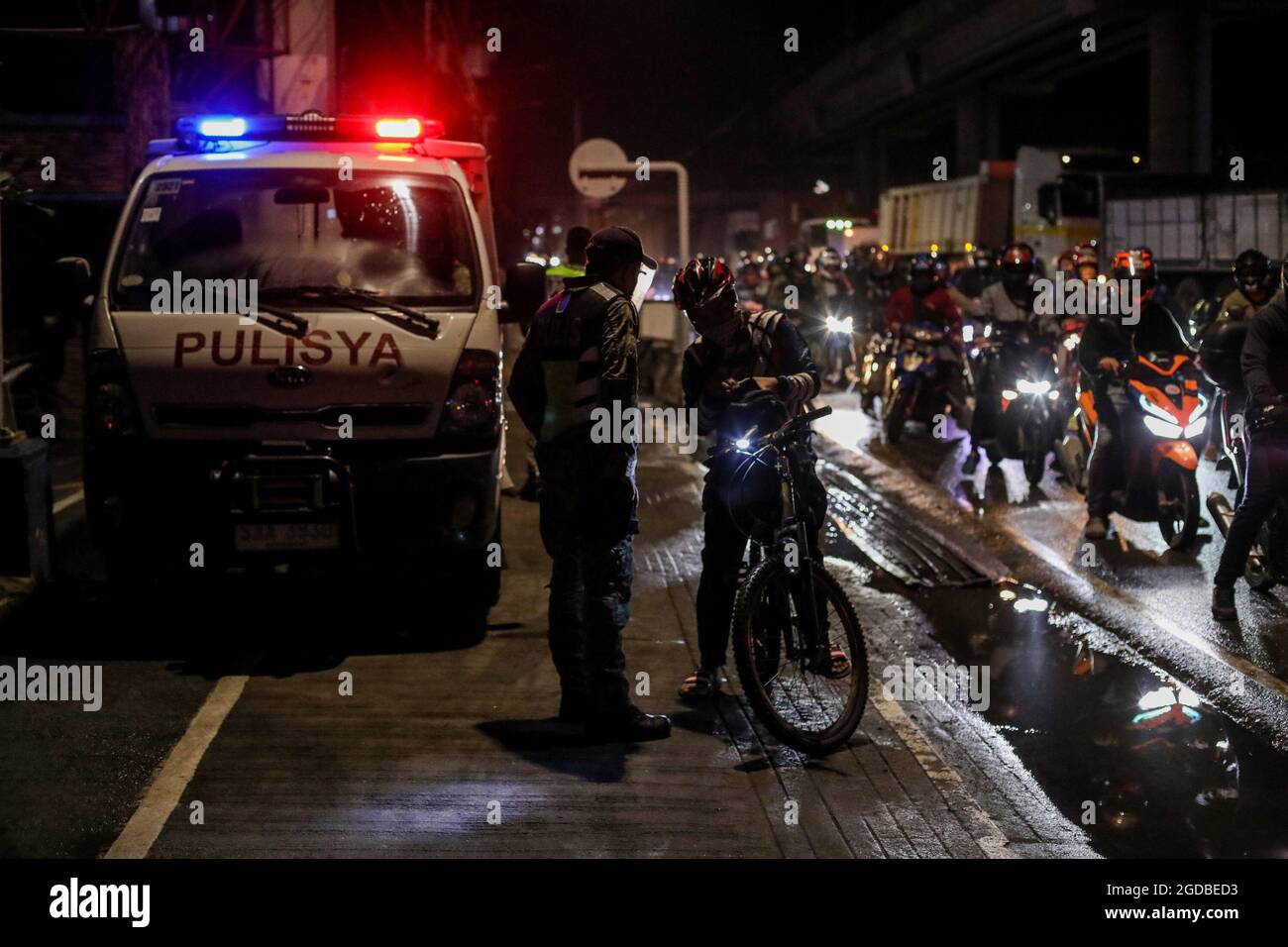 Policemen wearing protective equipment inspect motorcycle riders at a ...