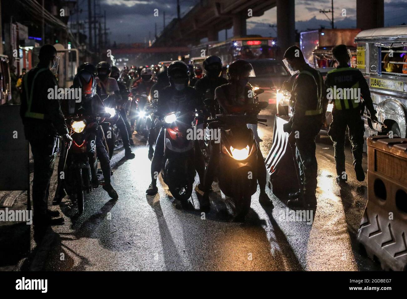 Policemen wearing protective equipment inspect motorcycle riders at a ...