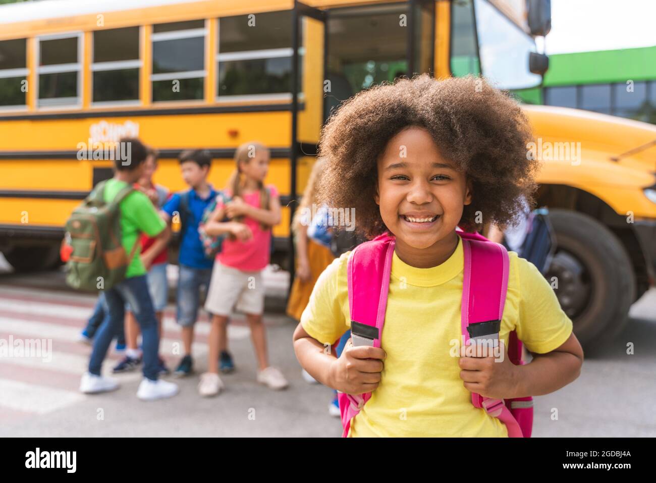 Group of young students attending primary school on a yellow school bus ...