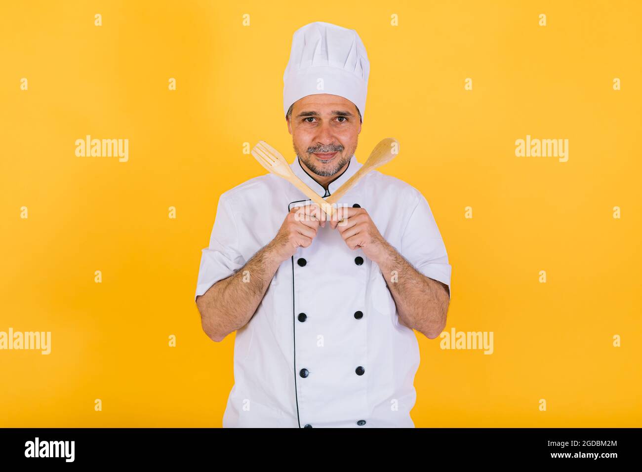 Chef cook wearing white kitchen cap and jacket with wooden spoon and ...