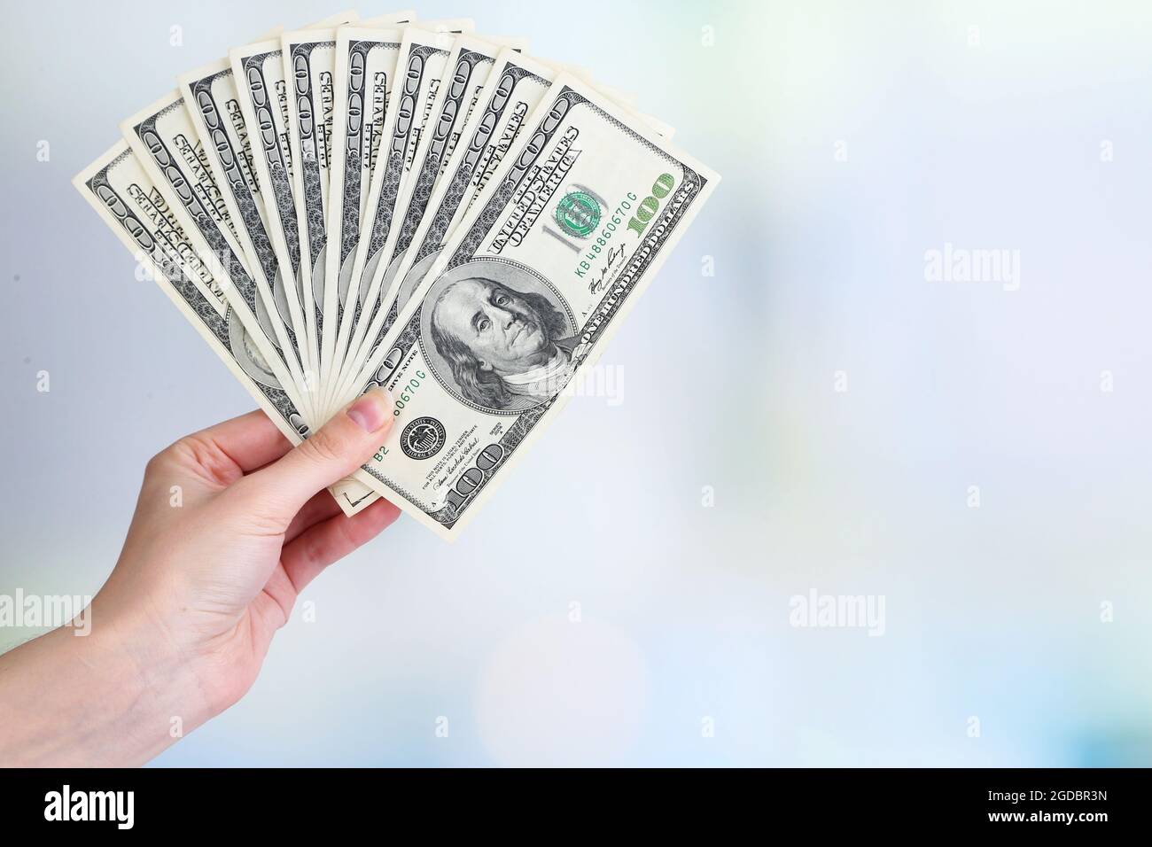 Dollars in hand on bright background Stock Photo - Alamy