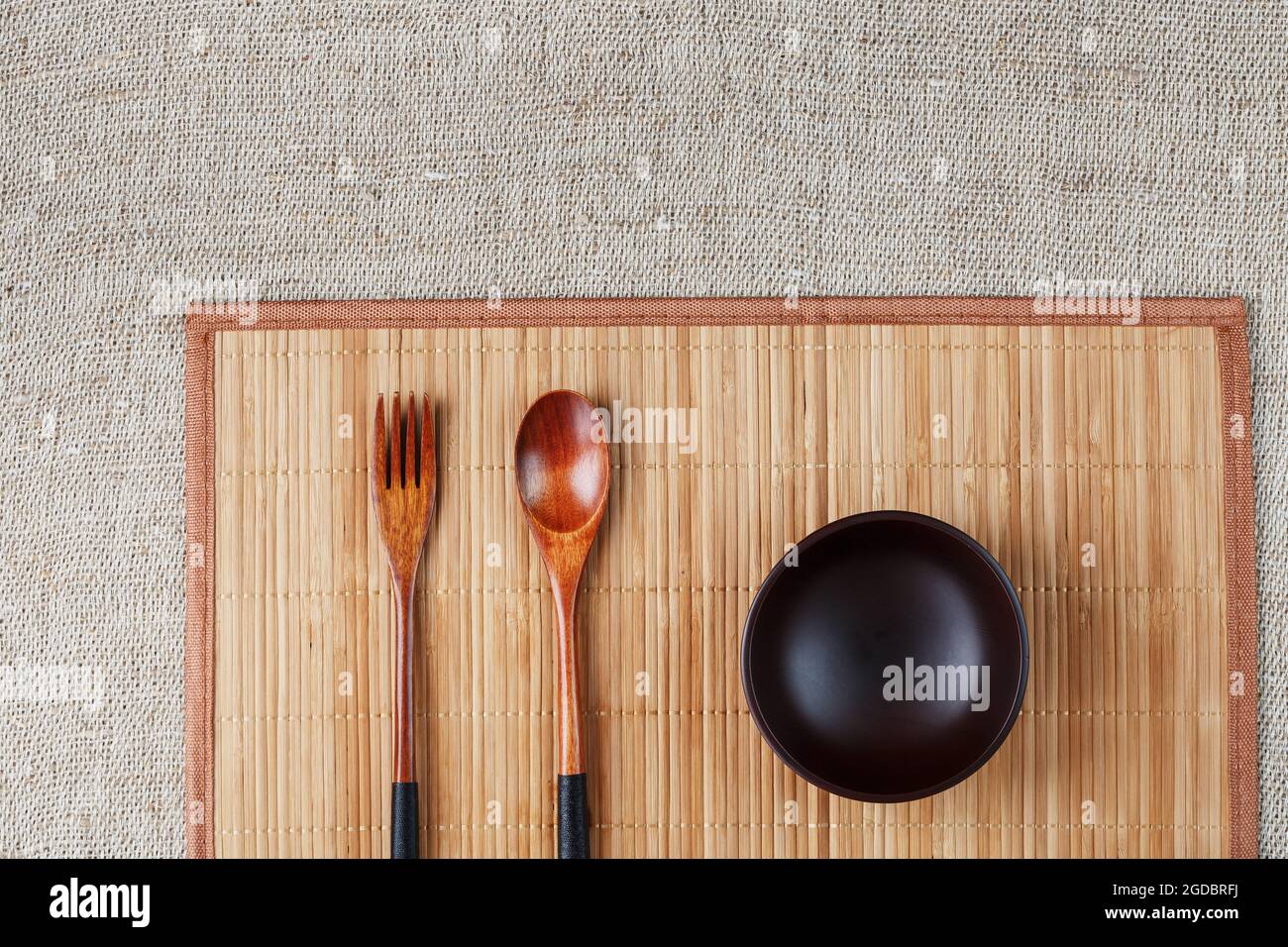 Natural wood plate, spoon and fork on a bamboo backing. Asian food ...