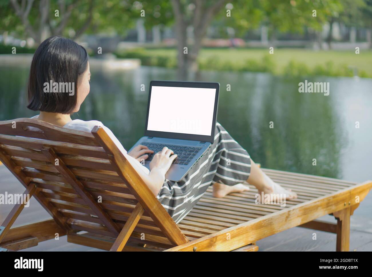 Woman using laptop swimming pool hi-res stock photography and images ...