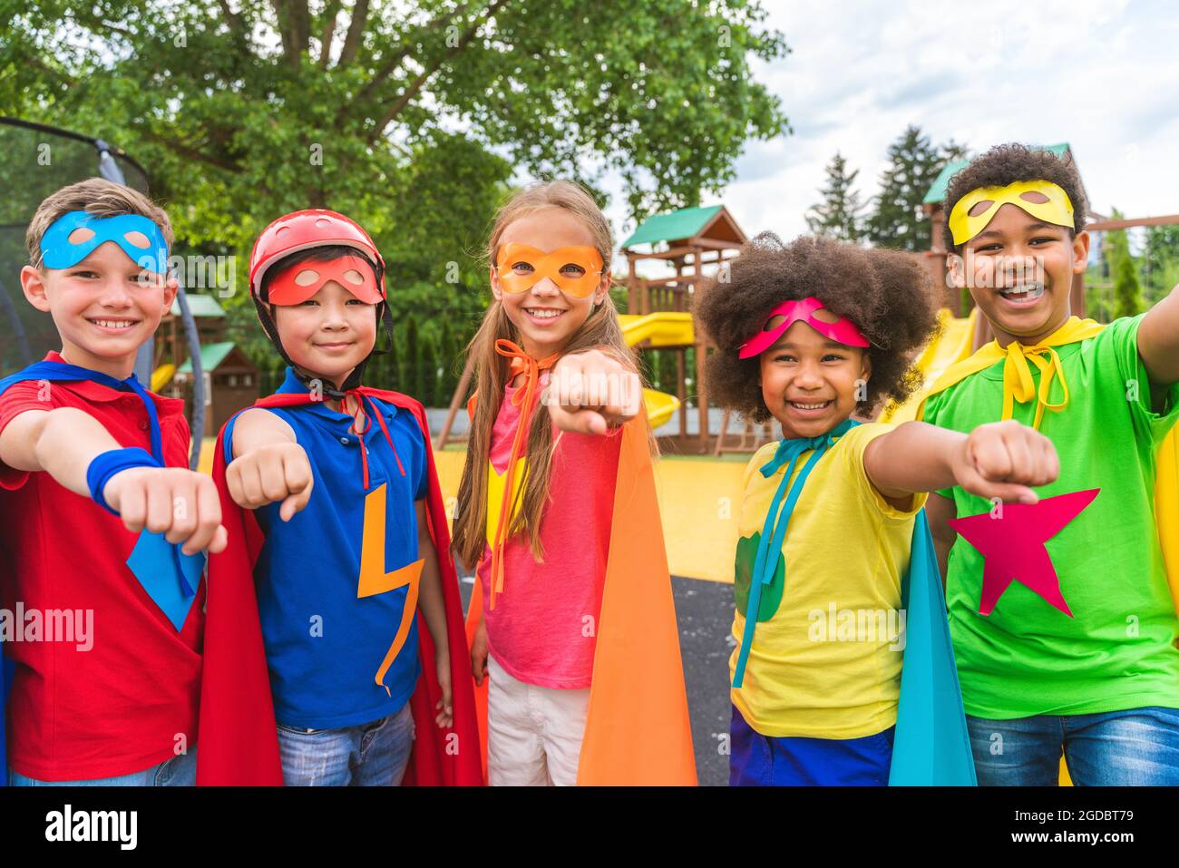 Multiracial group of young schooler wearing superhero costumes and ...