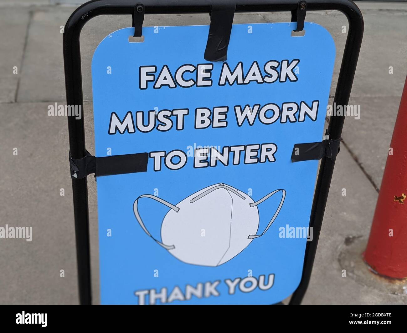 Sign "Face mask must be worn to enter" in the street Stock Photo - Alamy