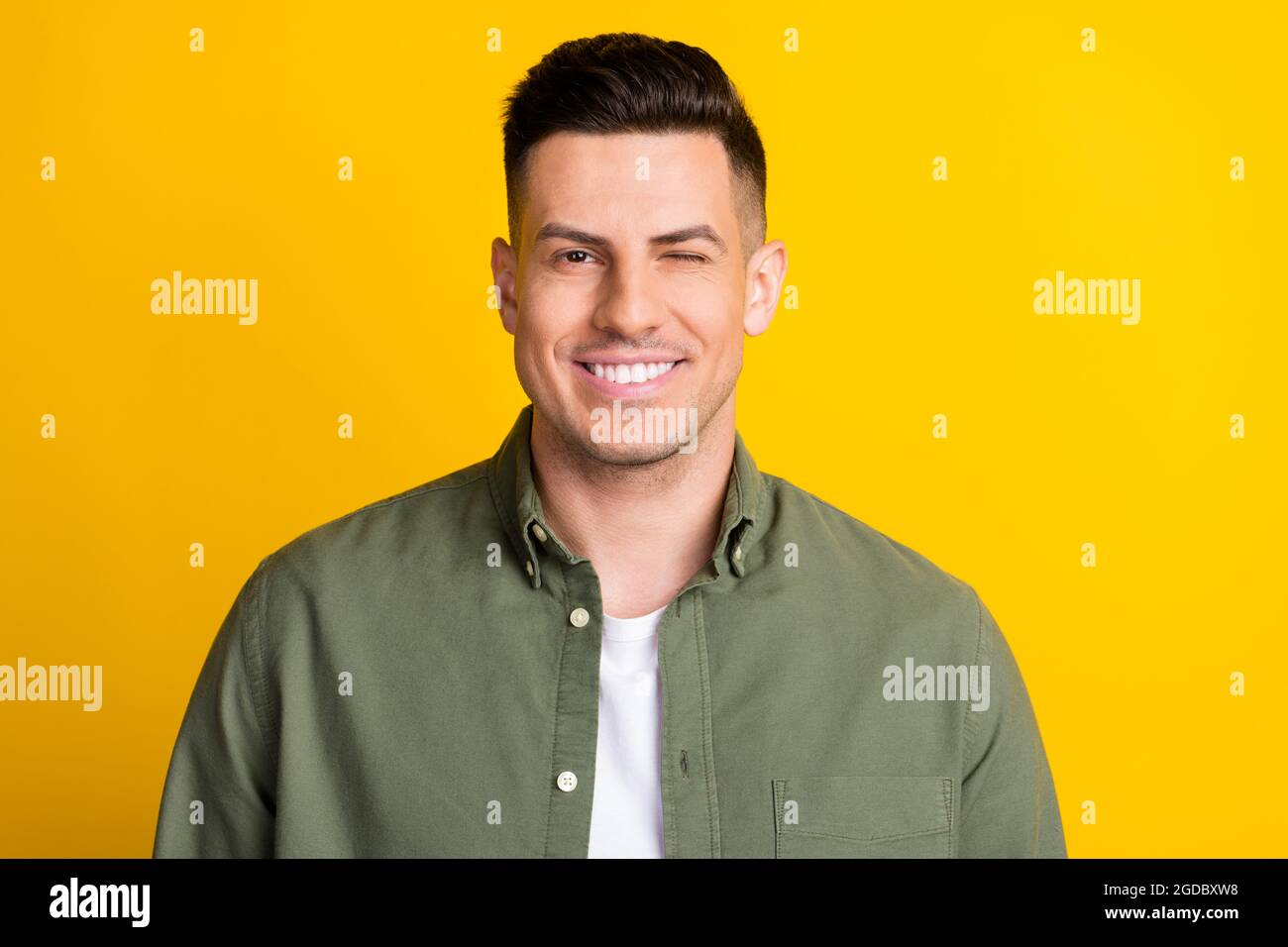 Photo portrait man wearing shirt smiling winking isolated bright yellow ...