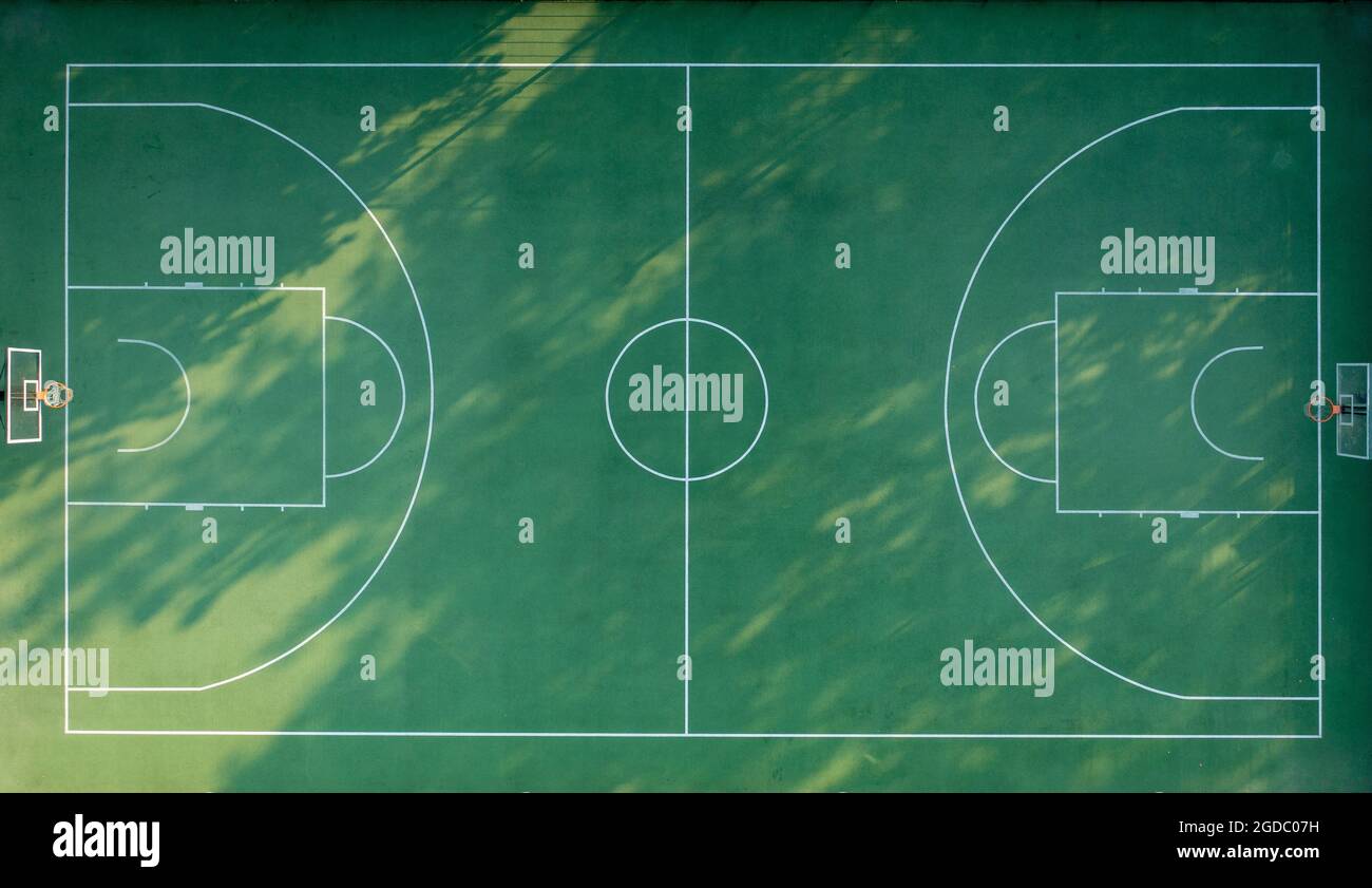 Sports football field, playground with green grass. Shade from trees on ...