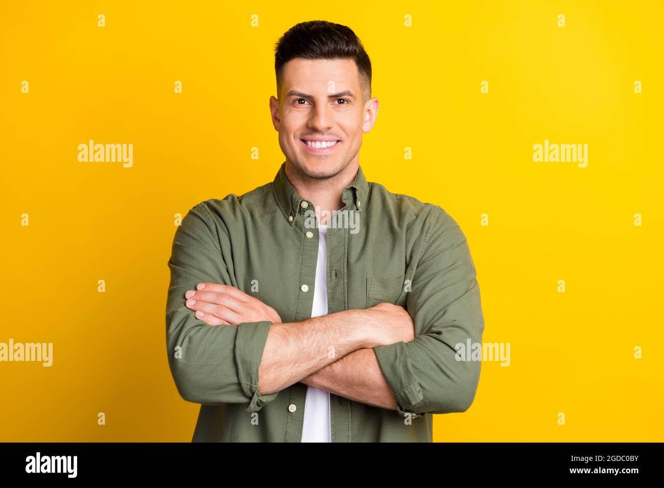 Photo portrait man smiling crossed hands isolated vivid yellow color ...