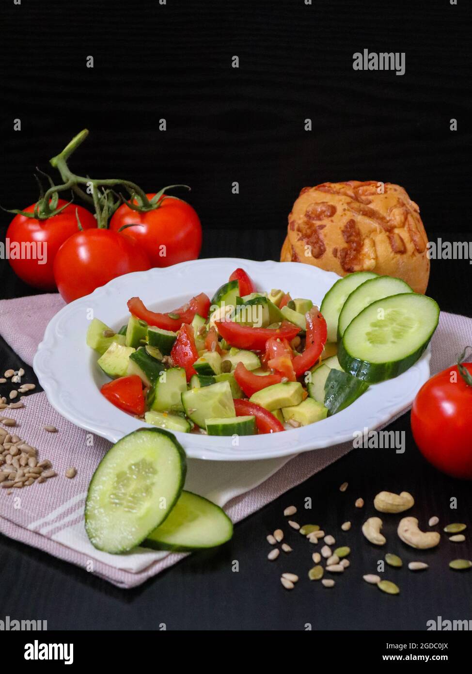 Avocado cucumber tomato salad in a white plate Stock Photo - Alamy