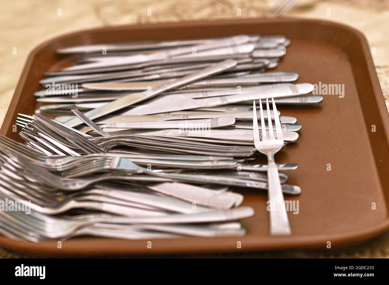 Many forks and knives lay on a brown tray Stock Photo - Alamy
