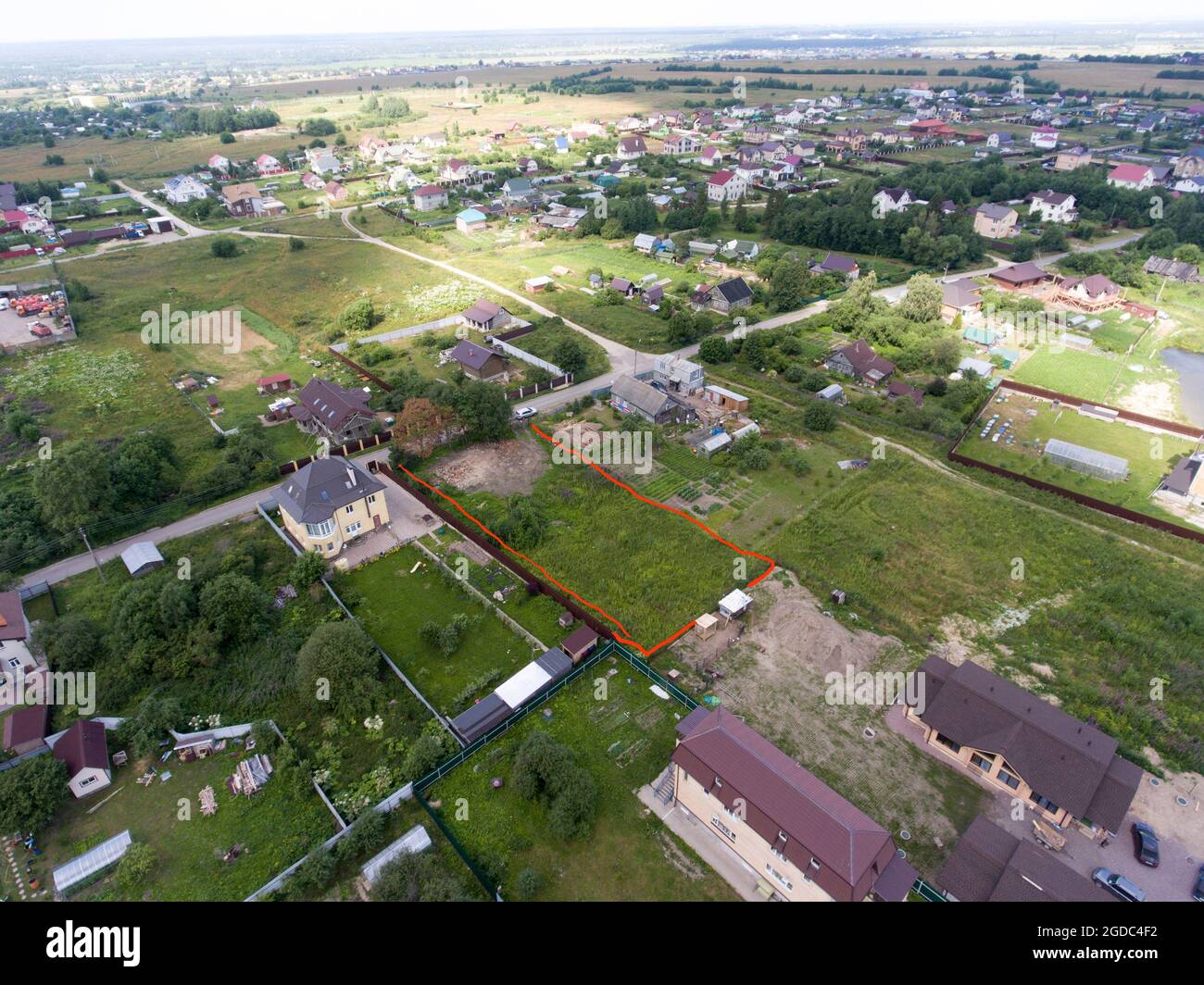 Aerial view at a village with summer houses and cottages close to road ...
