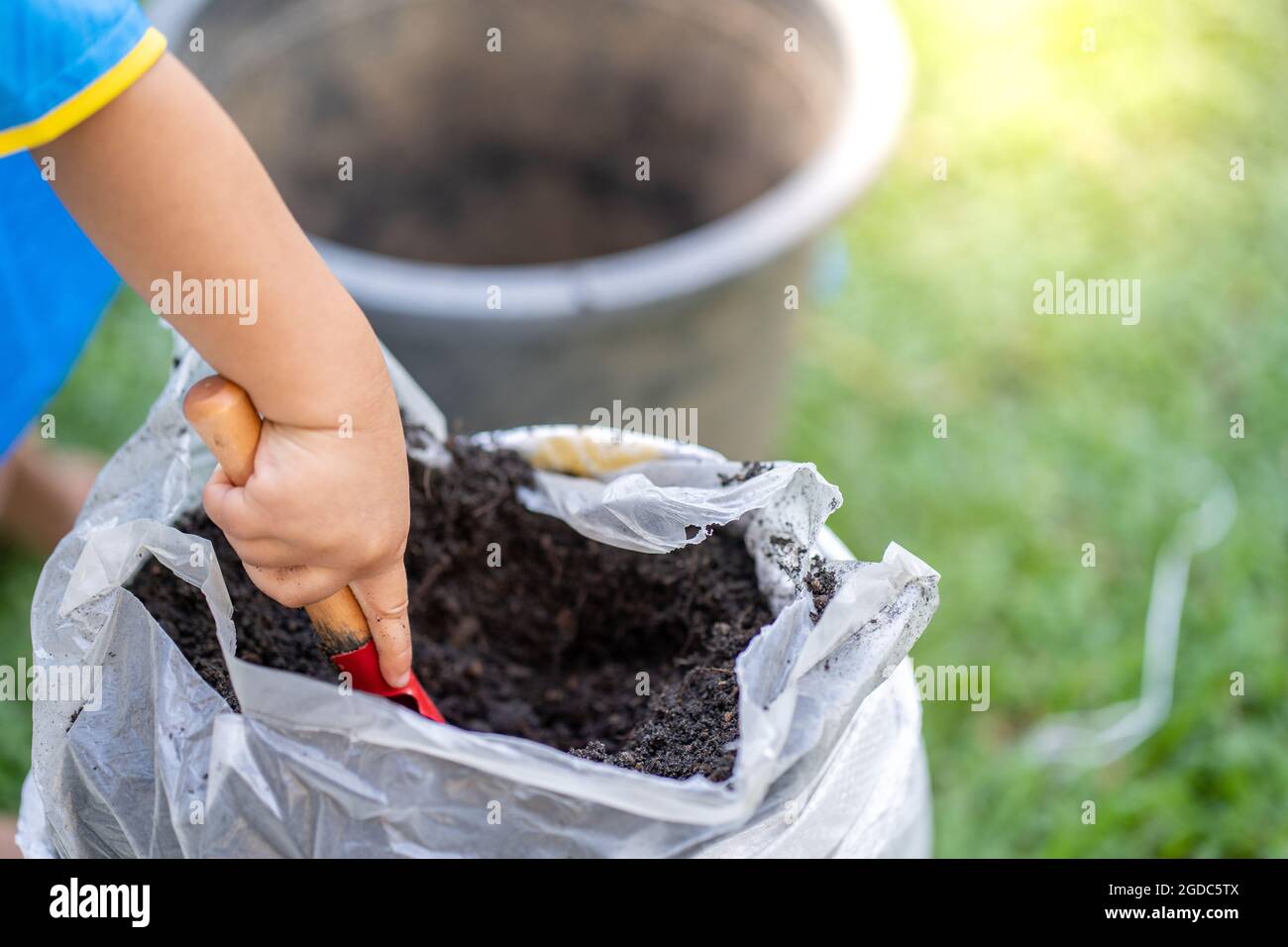 Person picking up the soil from the plastic bag with a shovel Stock ...