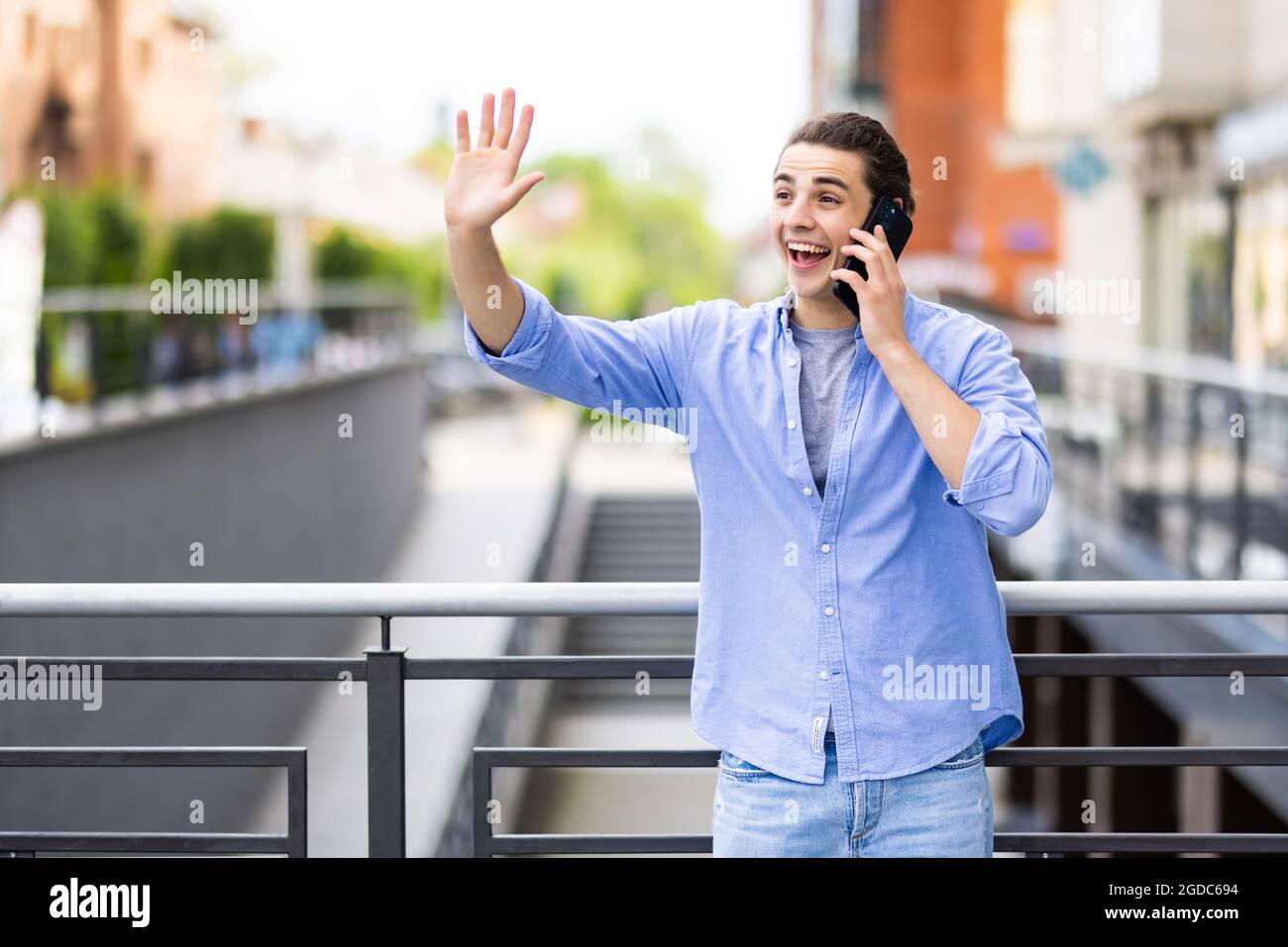 Happy man having walk in the city and use phone greeting someone Stock ...