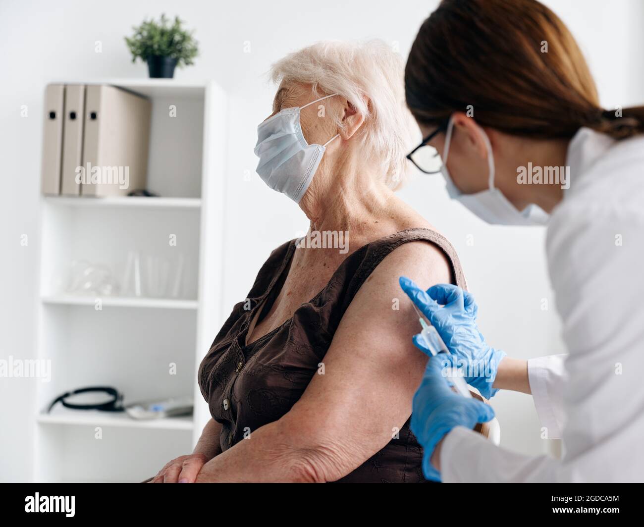 Nurse giving injection to woman patient immunization safety Stock Photo ...