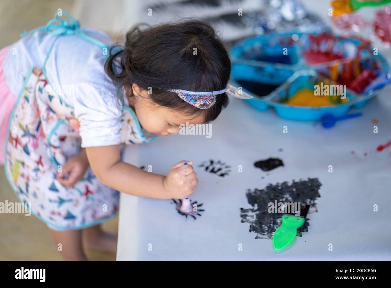 Adorable Asian female child doing crafts at preschool Stock Photo - Alamy