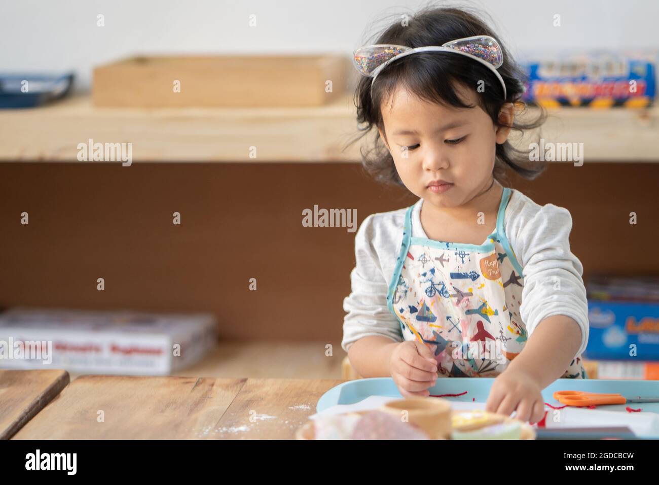 Adorable Asian female child doing crafts at preschool Stock Photo - Alamy