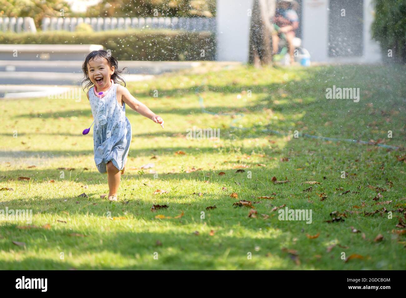 Cute Asian female child running on a meadow Stock Photo - Alamy