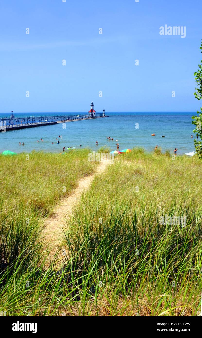 Path leads to beach where people are enjoying playing and swimming in ...