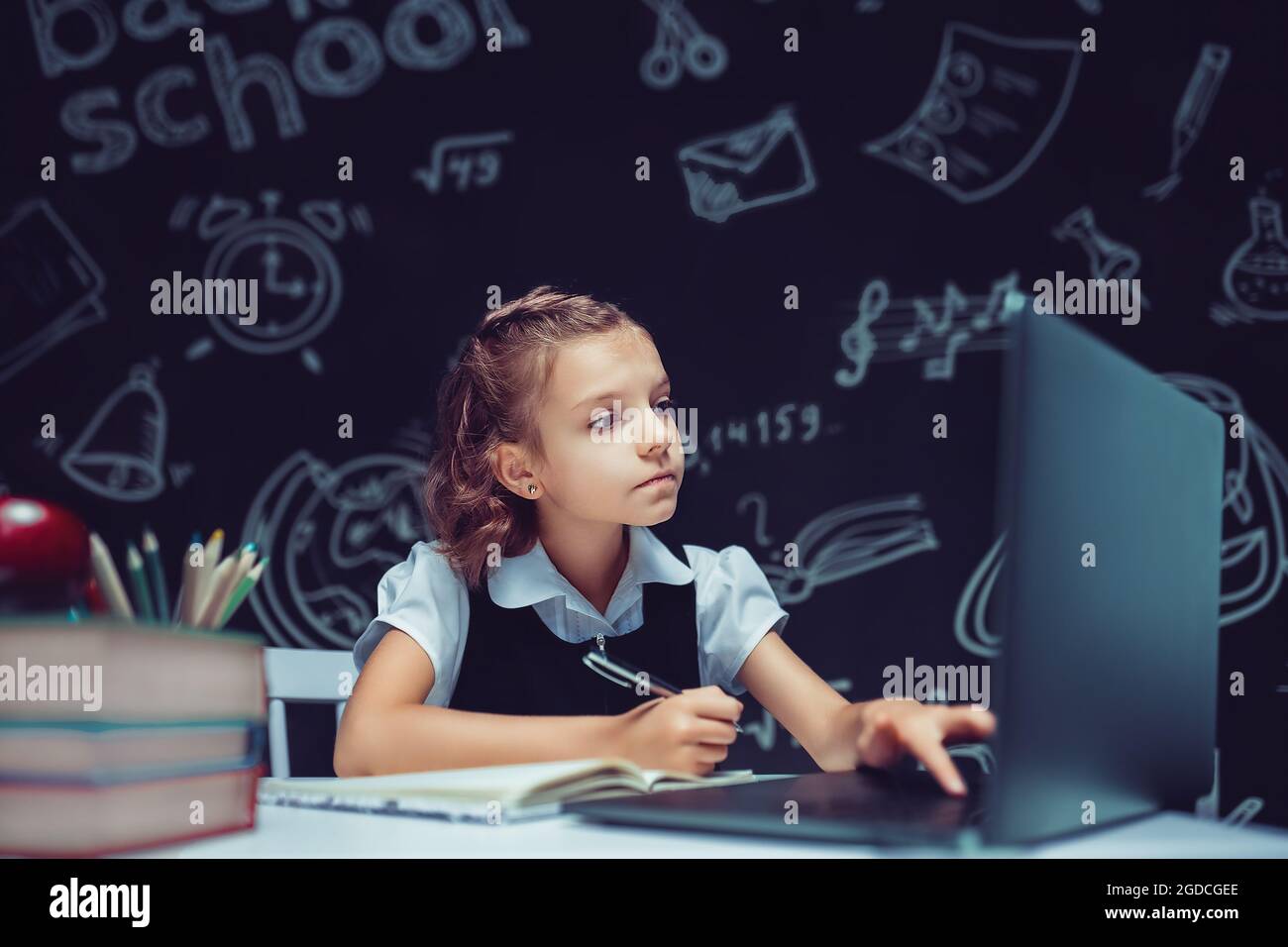 Happy teen school student studying with laptop books doing online ...