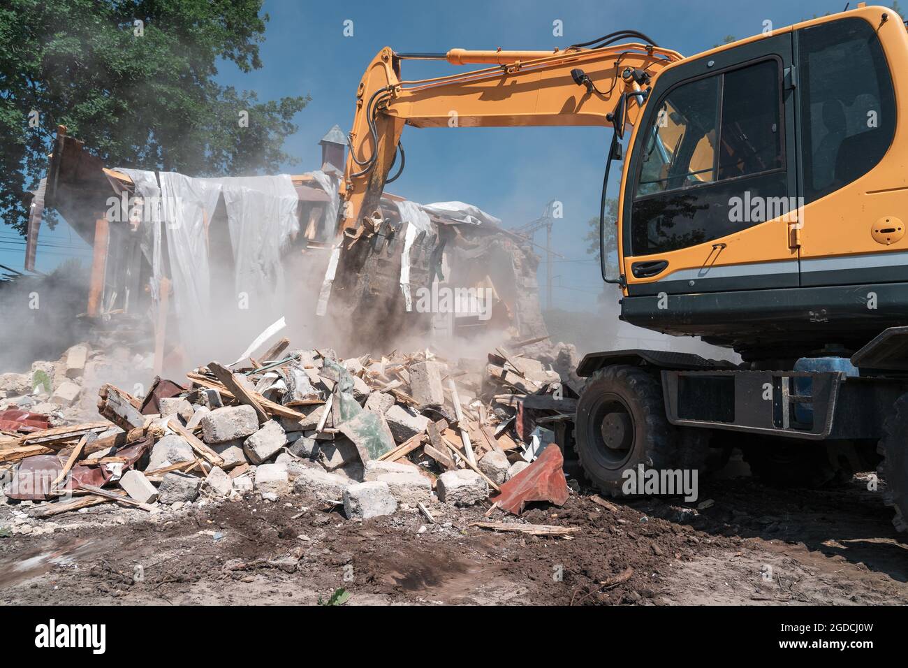 House demolition. Big yellow excavator breaks building for new ...