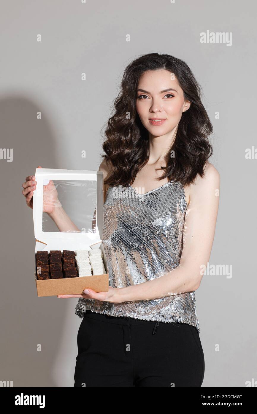 Slender model with gift. Copy space. Isolated on grey background Stock ...