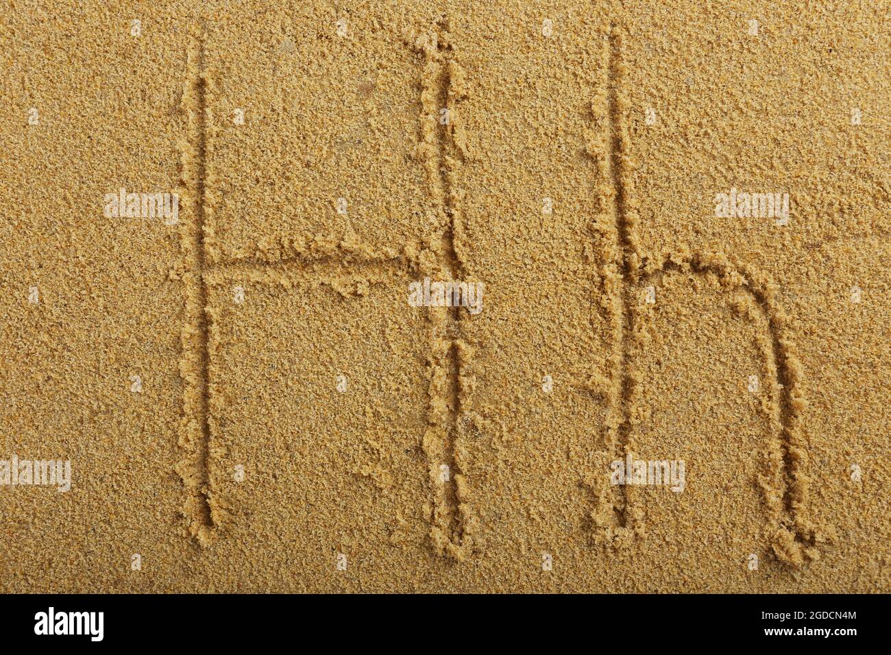 Alphabet letter written on wet beach sand Stock Photo - Alamy