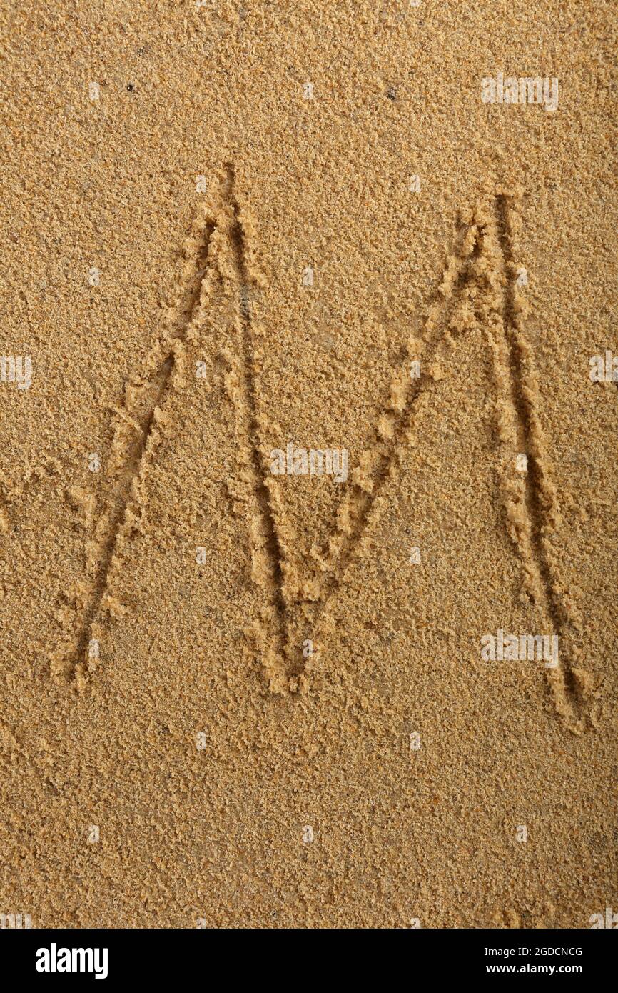 Alphabet letter written on wet beach sand Stock Photo - Alamy