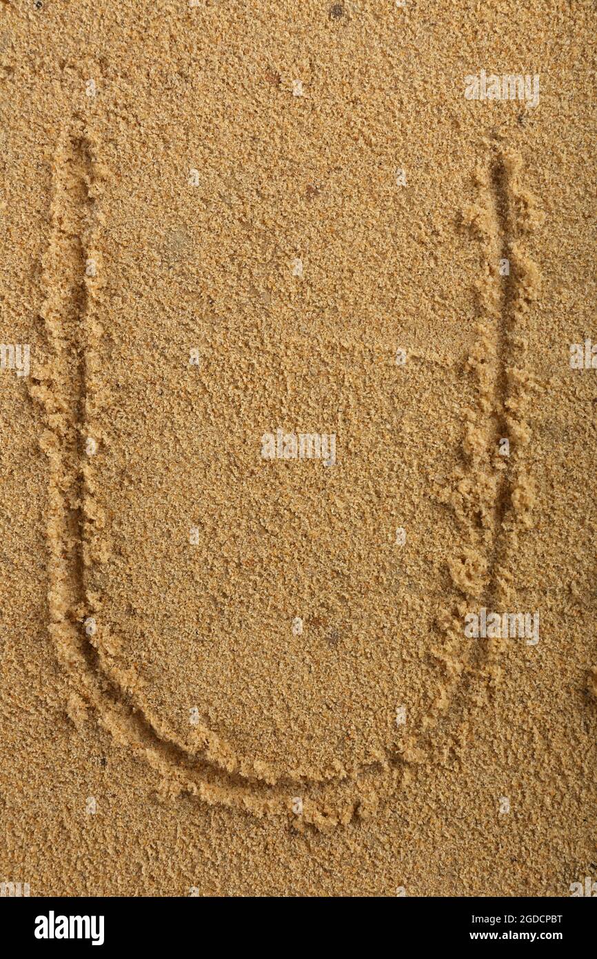 Alphabet letter written on wet beach sand Stock Photo - Alamy