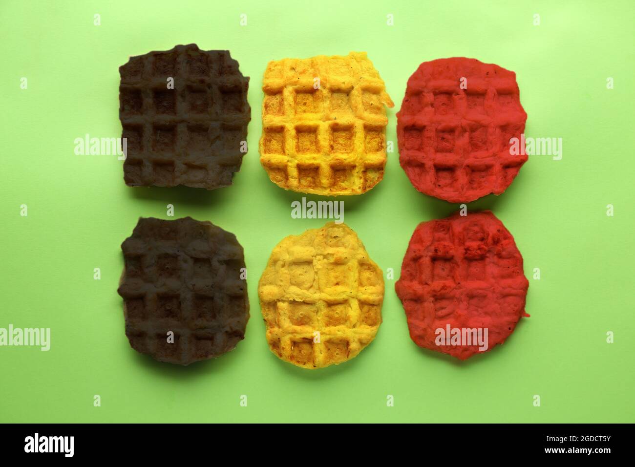 Delicious waffles in colors of Belgian flag on green background Stock ...