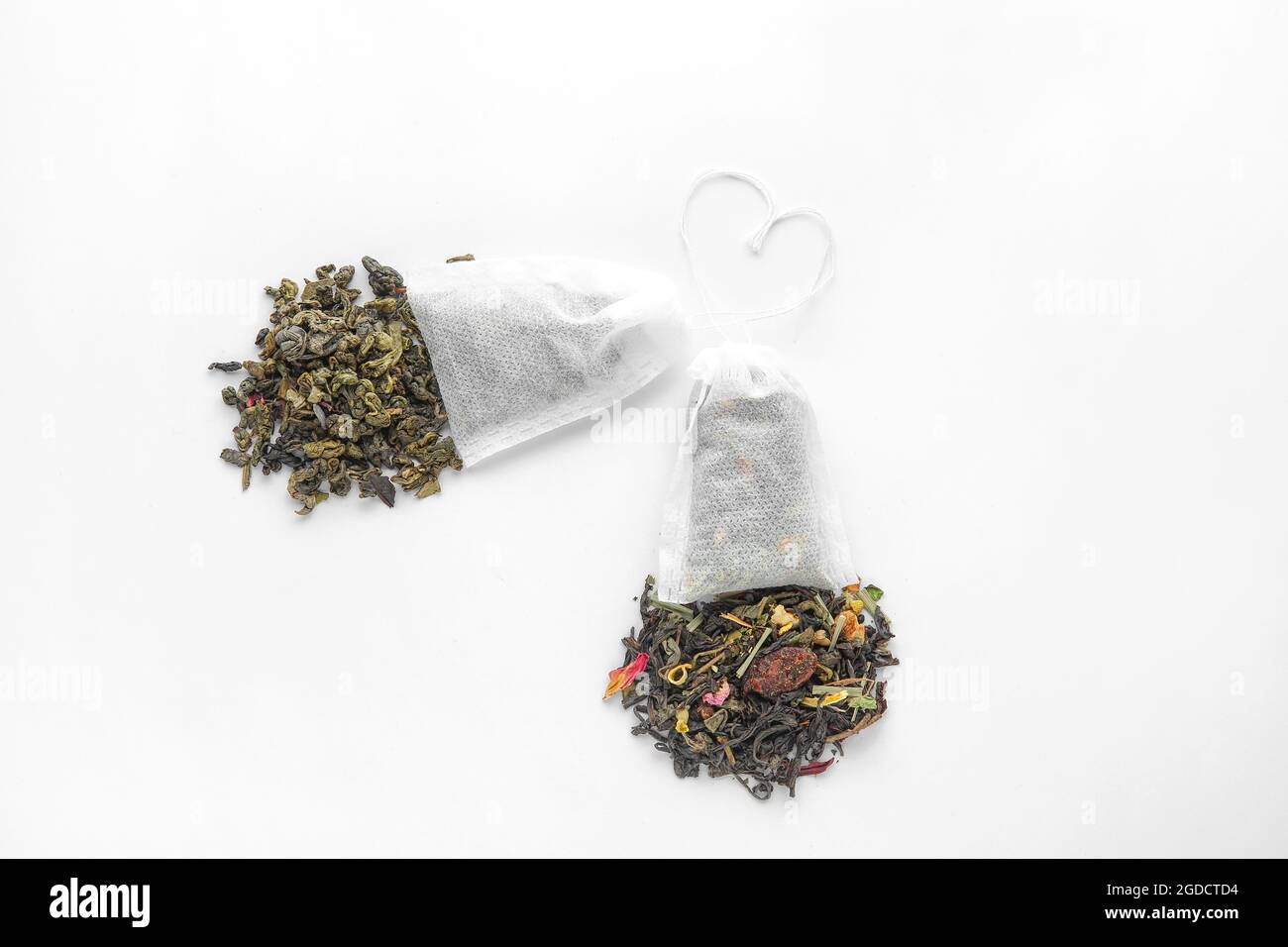 Tea bags with dry leaves on white background Stock Photo - Alamy