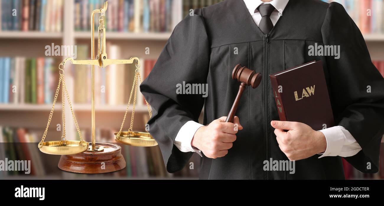 Male judge with gavel and scales of justice in library Stock Photo - Alamy