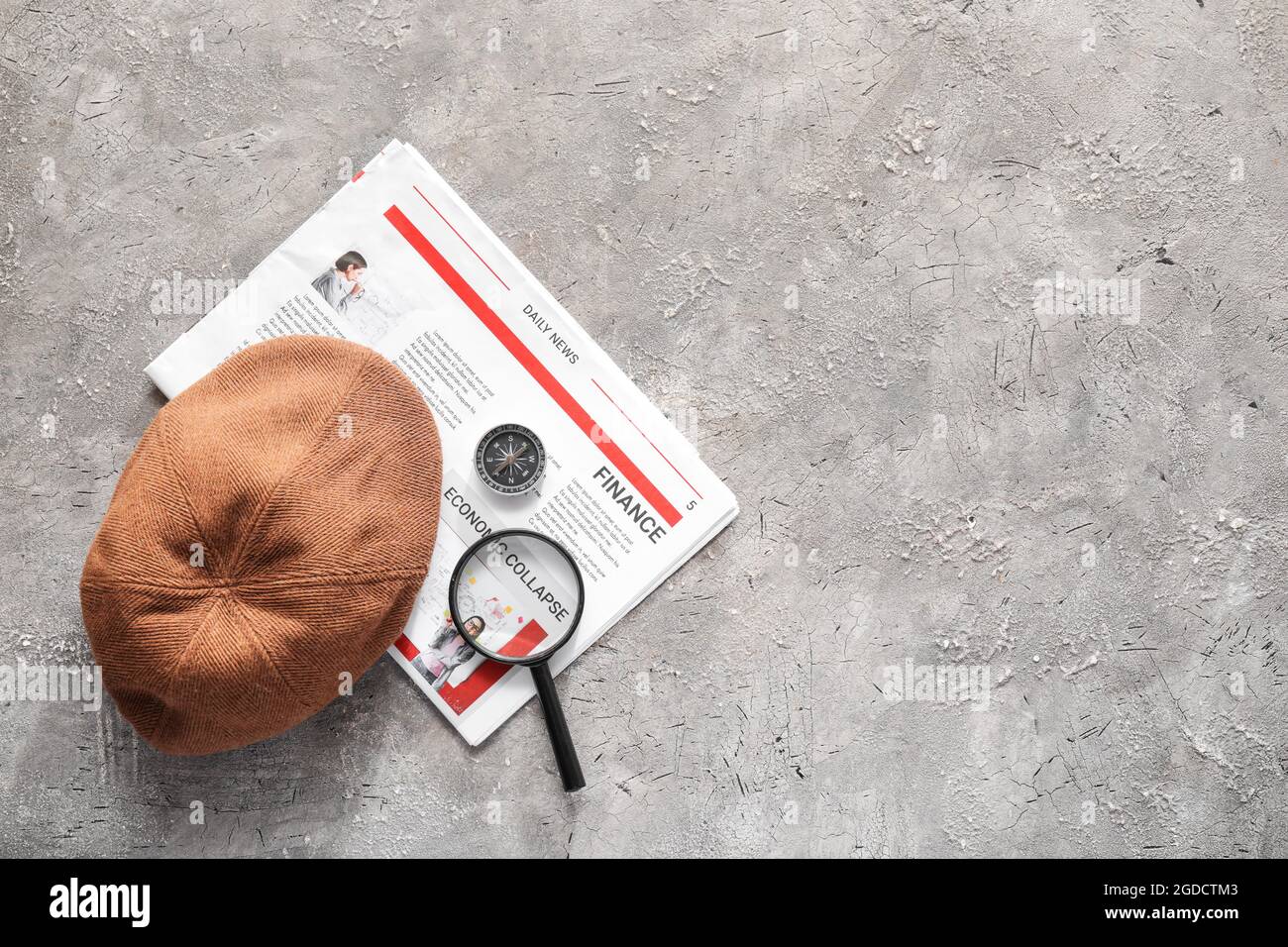 Stylish cap, newspaper, magnifier and compass on grunge background ...